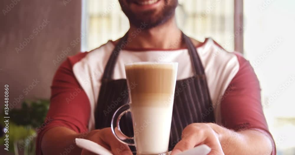 Smiling waiter holding glass of cold coffee at counter in cafÃ© 4k ...