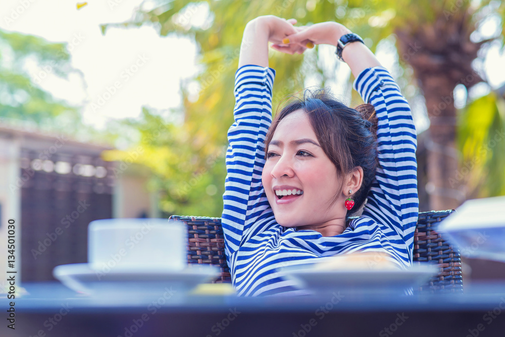 girl sitting on chair by outstretched arm for relaxing in outdoor ...