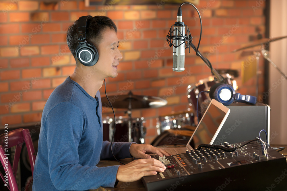 DJ working at radio broadcasting studio,hands adjusting volume and ...