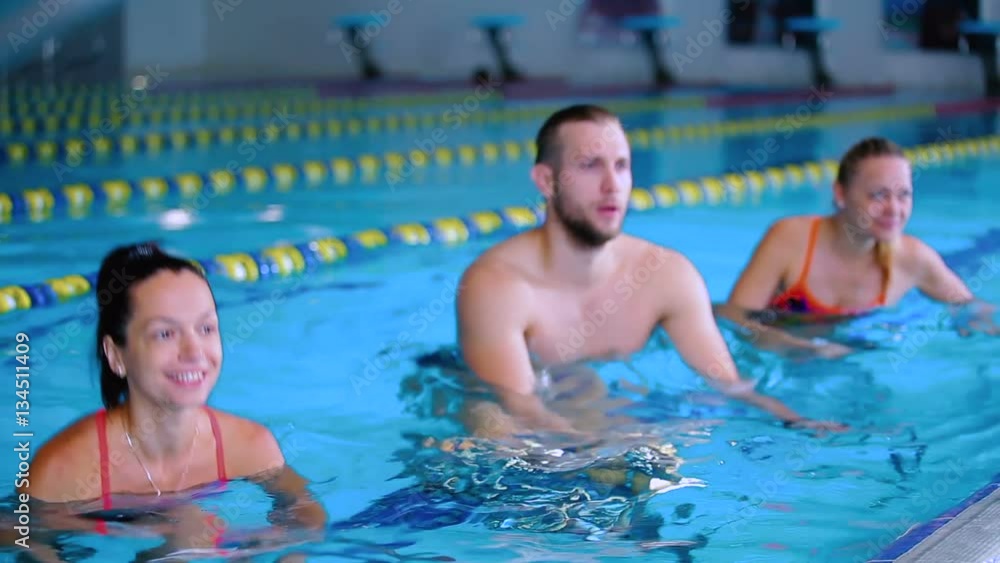 Two young women and man doing water aerobics in the swimming pool Stock ...