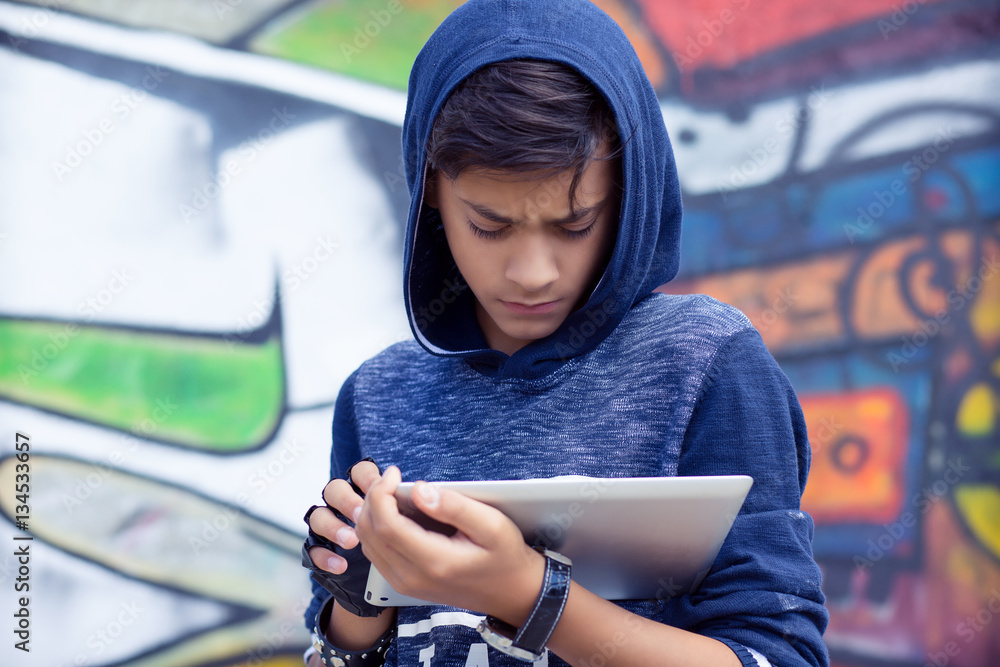 child, angry funny looking boy using, holding laptop, pad computer on ...