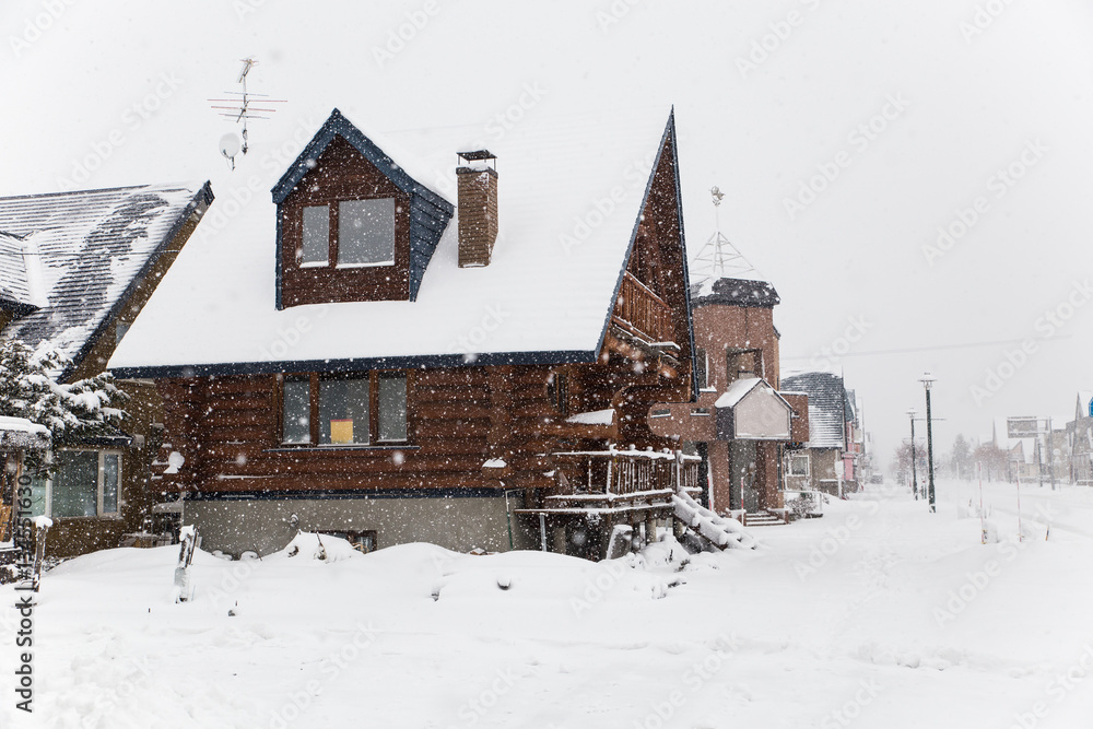 Winter scene of wooden house or chalet covered with a fresh snow powder ...