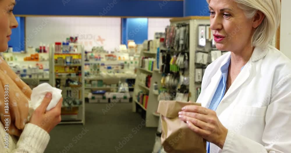 Pharmacist assisting the package of drug to customer in pharmacy Stock ...