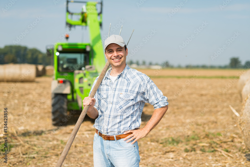 Portrait of a smiling farmer holding a pitchfork Stock Photo | Adobe Stock