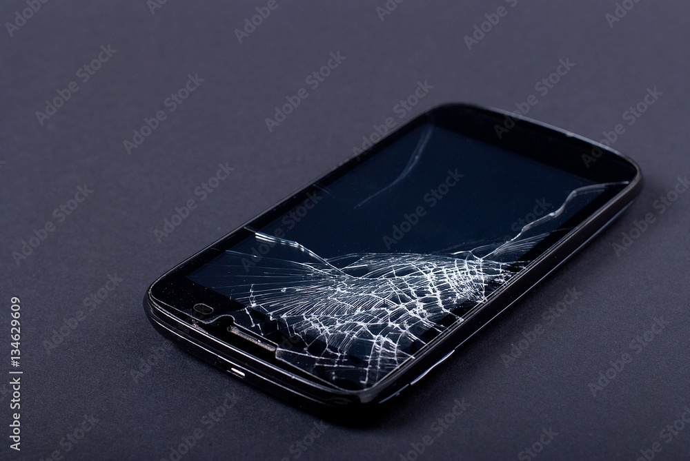 phone with a broken screen on the table Stock Photo | Adobe Stock