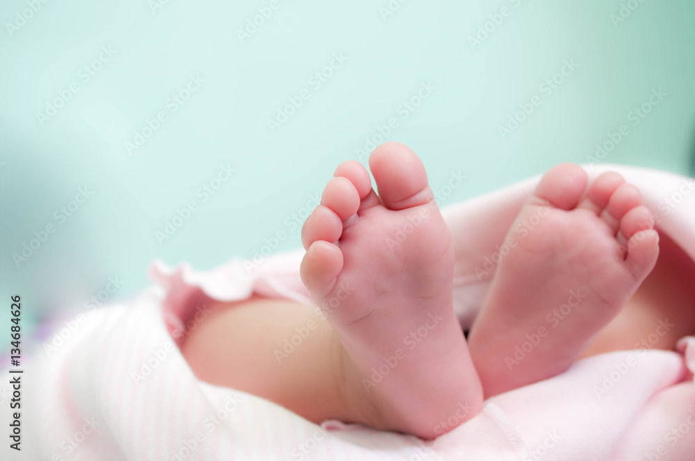 Premature baby feet with little toes, pink blanket, and turquoise ...