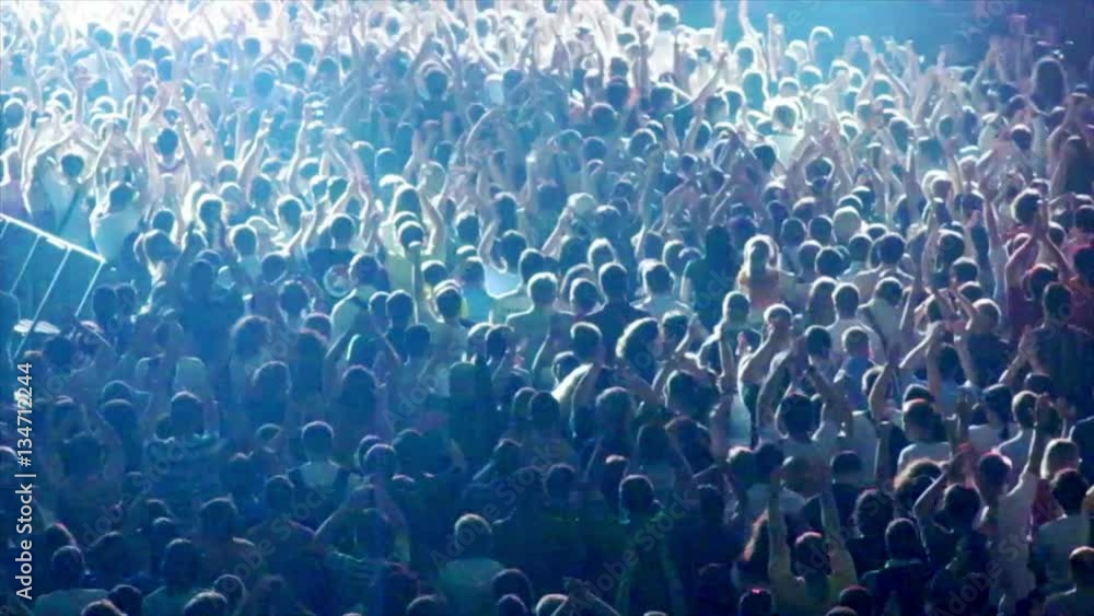 Cheering crowd at a music concert. Audience raising up hands and ...