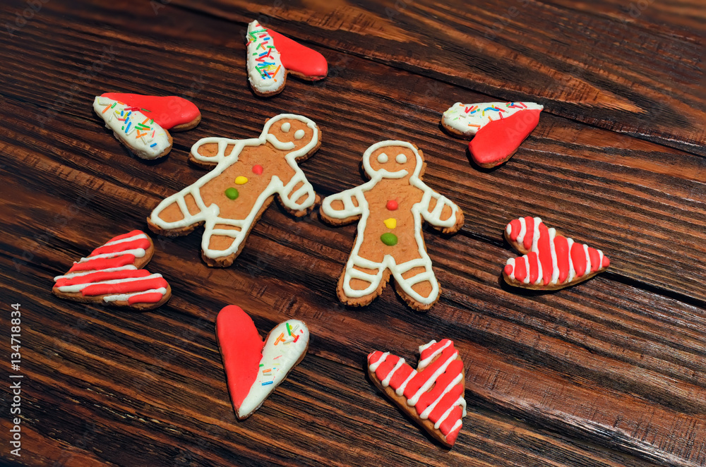 Two handmade cookie in the shape of men and heart in the middle between ...