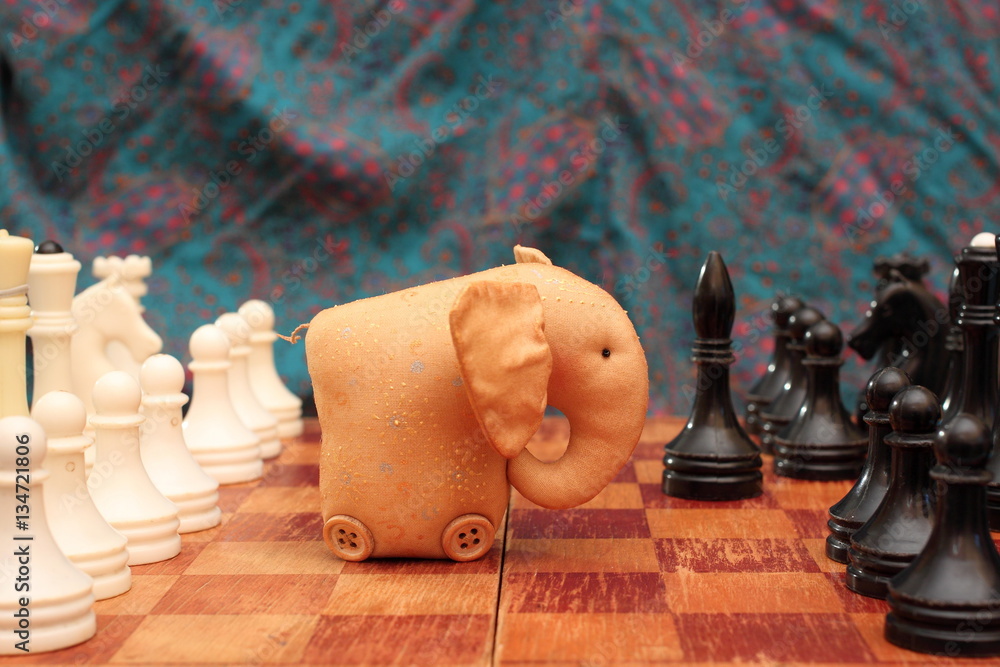 Little toy soft fabric handmade elephant among chess figures on ...