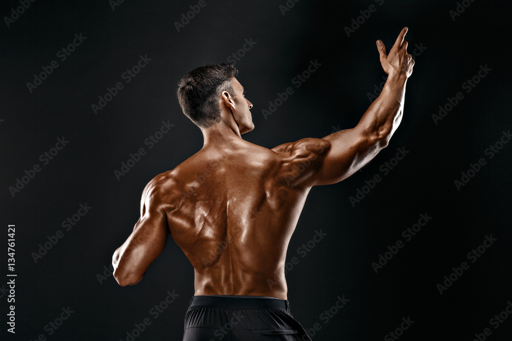 Back view of Unrecognizable man, strong muscles posing with arms up ...