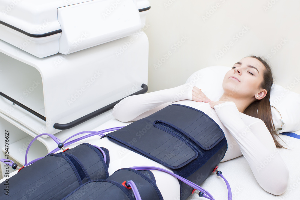Woman at the clinic for the treatment of pressure therapy procedure ...