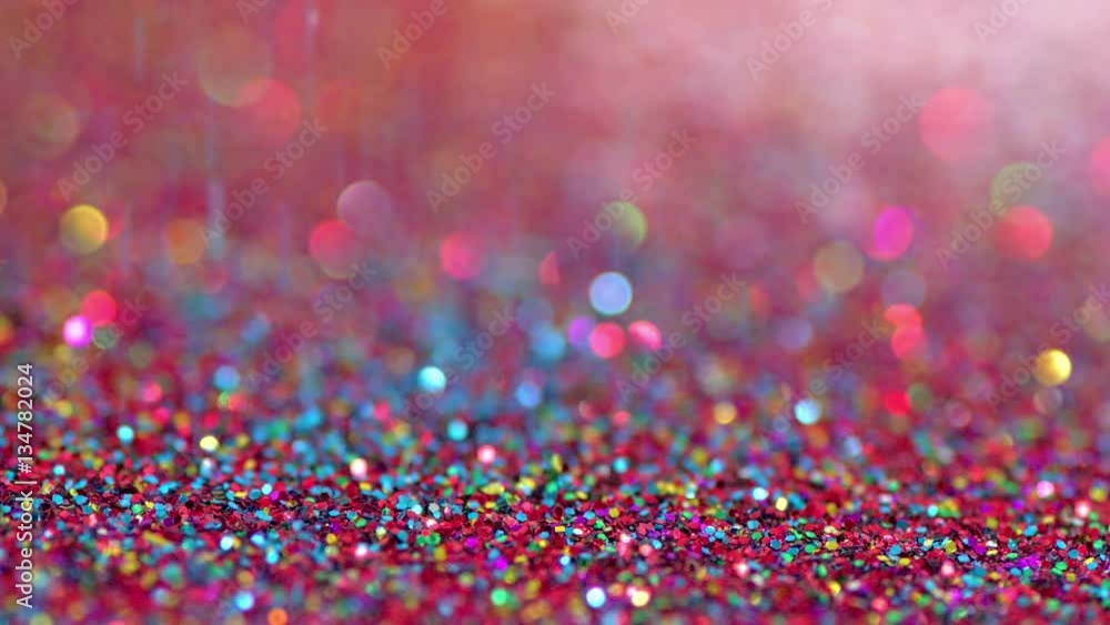 Colourful blue glitter falling on red glitter. Perfect party glitz and ...