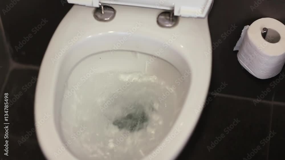 Water flows into the toilet bowl. Water stream flows into the toilet ...