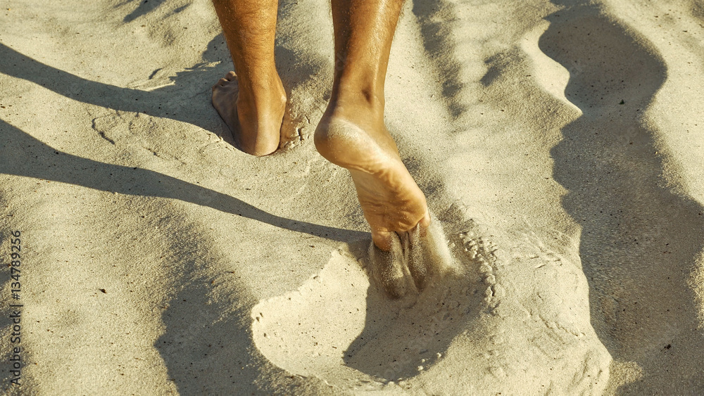 Male feet walking on sand. Tanned man crossing desert barefoot. Human ...