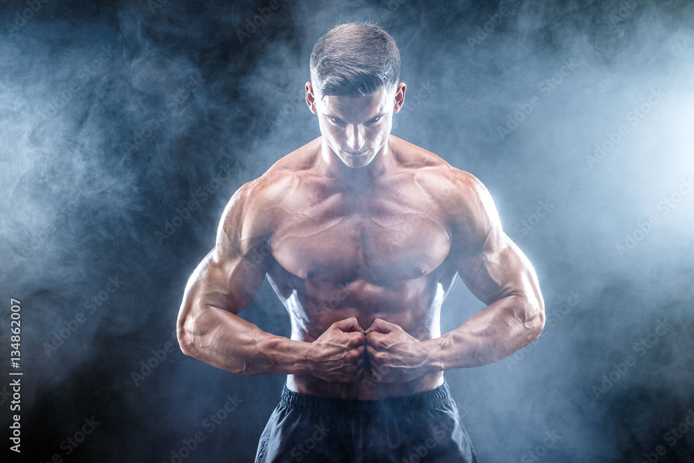 Strong bodybuilder man with perfect abs, shoulders,biceps, triceps ...