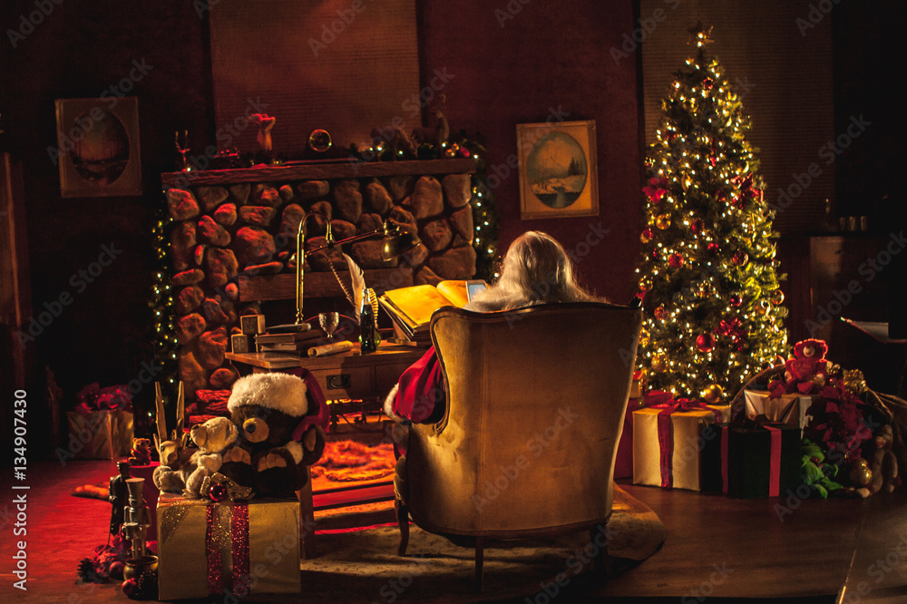 Santa sits at his desk, surrounded by festive Christmas decor and ...