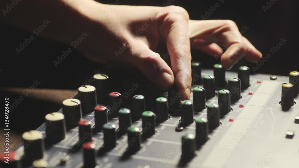 Close up video of a mixer desk with many buttons and and a hand ...
