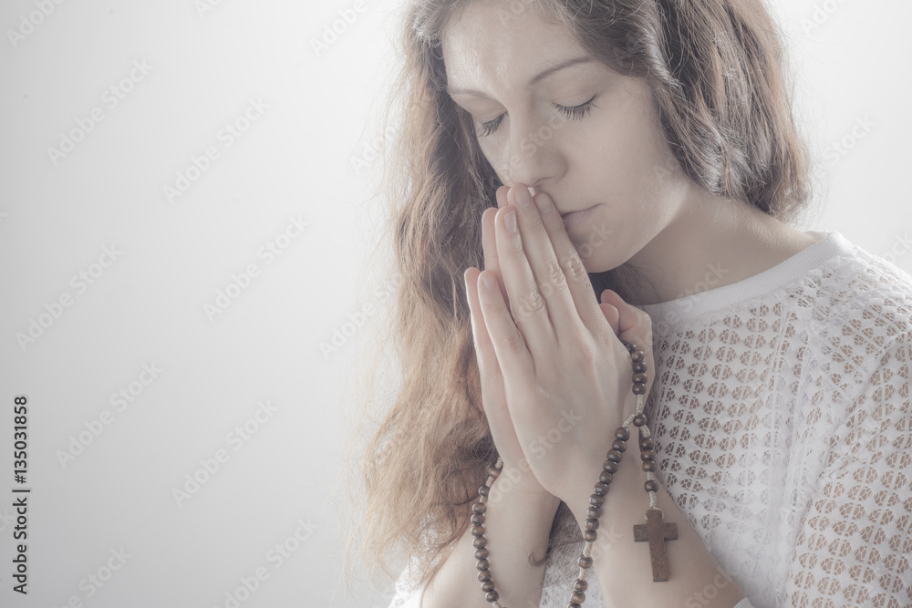 Praying woman on white background with shine. Stock Photo | Adobe Stock