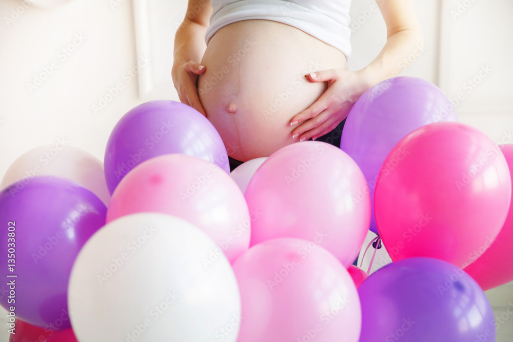 pregnant woman with a big belly is behind the colored balloons Stock ...