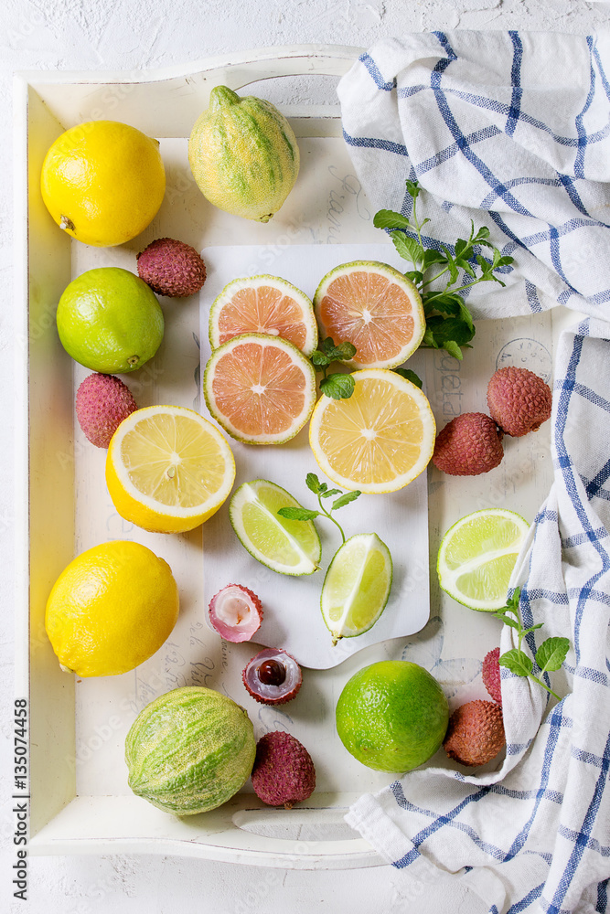 Variety of whole and sliced citrus fruits pink tiger lemon, lemon, lime ...