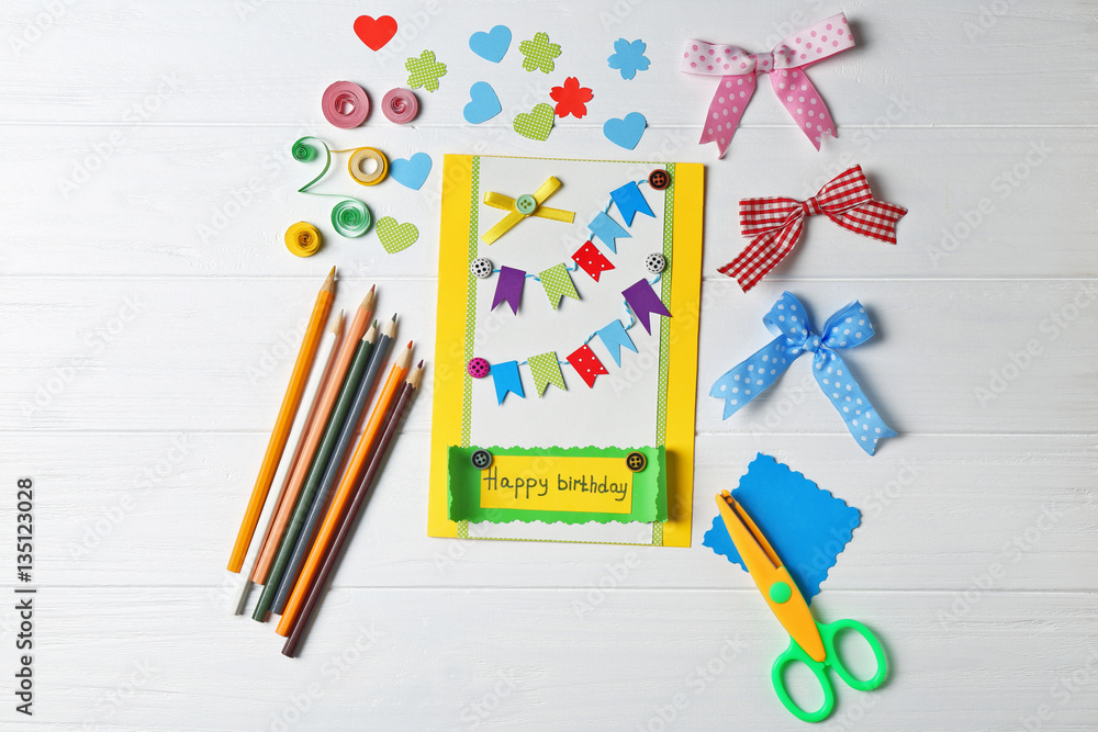 Handmade gift card and colorful crayons on white wooden background ...