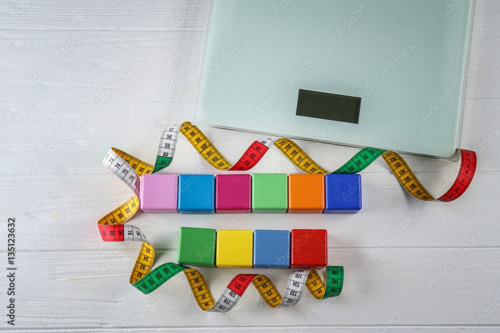 Measure tape, cubes with space for text and scales on wooden background Stock Photo | Adobe Stock