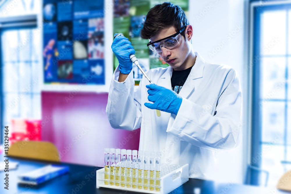 Young scientist examining chemical sample in a laboratory. Medical ...
