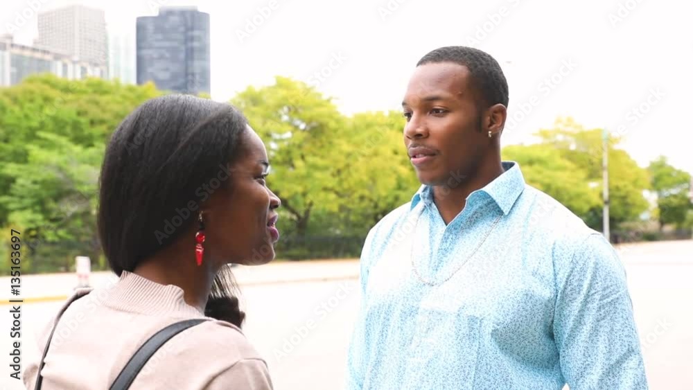 Happy black couple talking in Chicago. A man and a woman standing face ...
