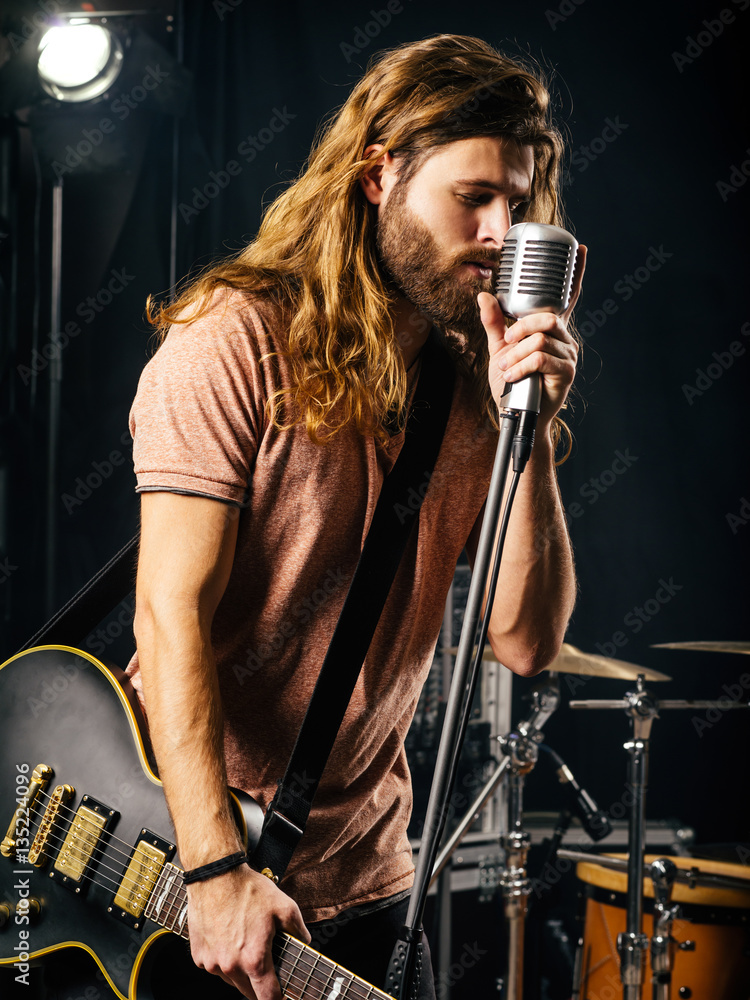 Young man singing and playing electric guitar on stage Stock Photo ...