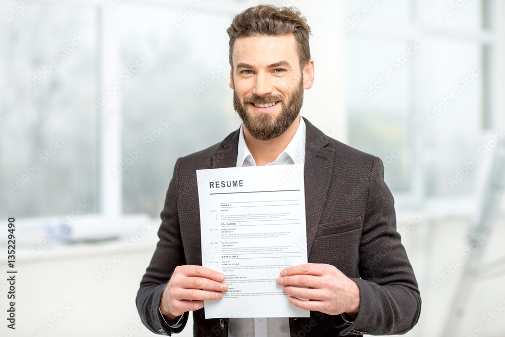 Elegant man in the suit holding resume for job hiring in the bright ...