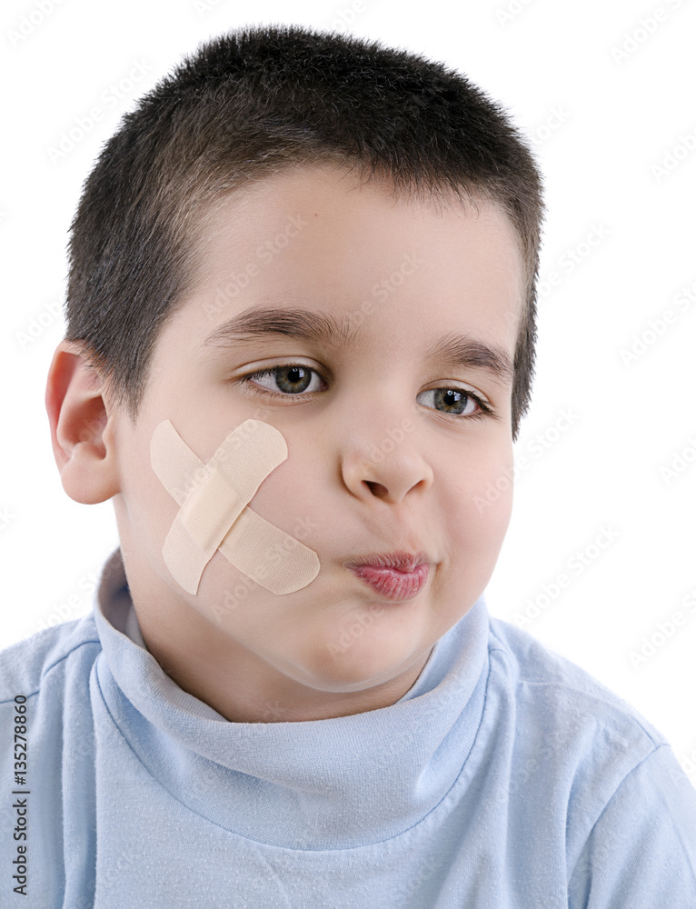 Child with band aid on his cheek looking at the space for your text ...