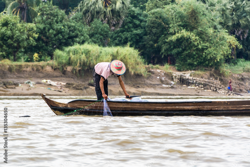 Burmese fisherman netting fish in a river near Yangon, Irrawaddy delta ...