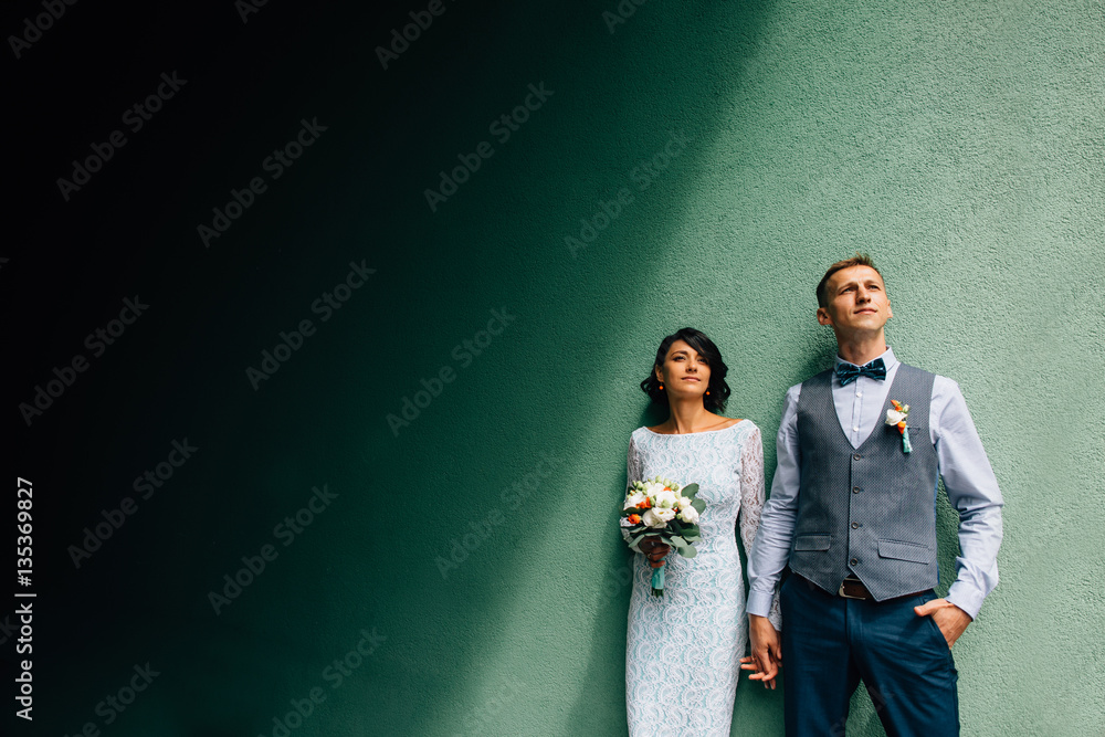 Wedding. Bride and groom on green wall background with copy space Stock ...