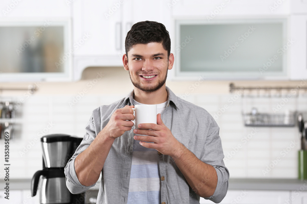 Handsome young man drinking coffee at home Stock Photo | Adobe Stock
