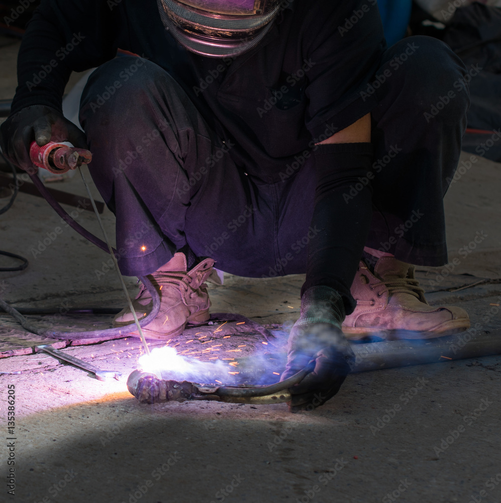 Man with welding helmet welding steel Stock Photo | Adobe Stock