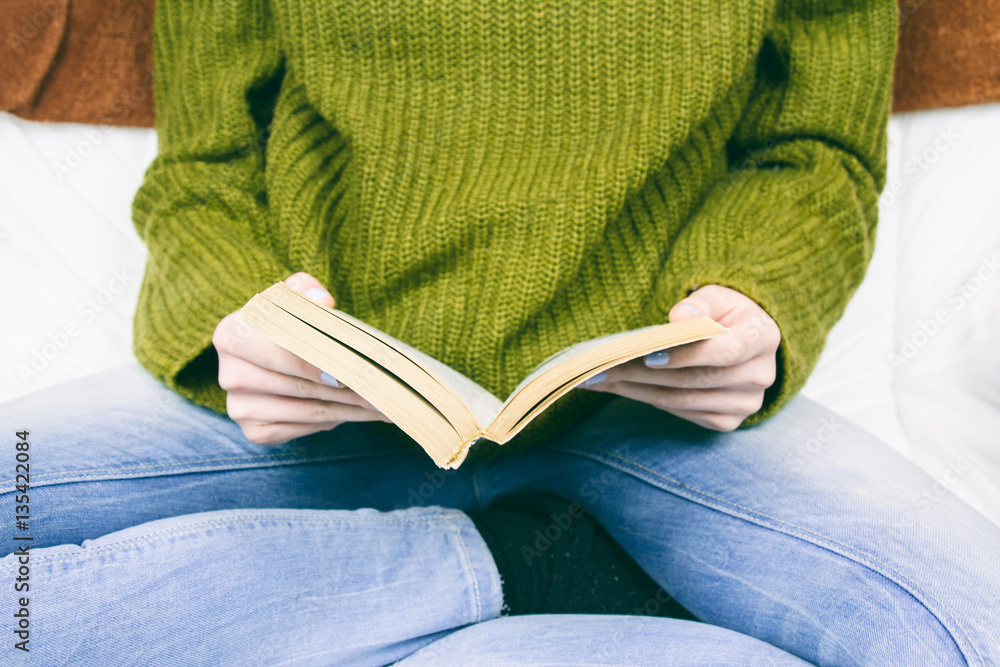 Persona con jersey verde y vaqueros leyendo un libro Stock Photo ...