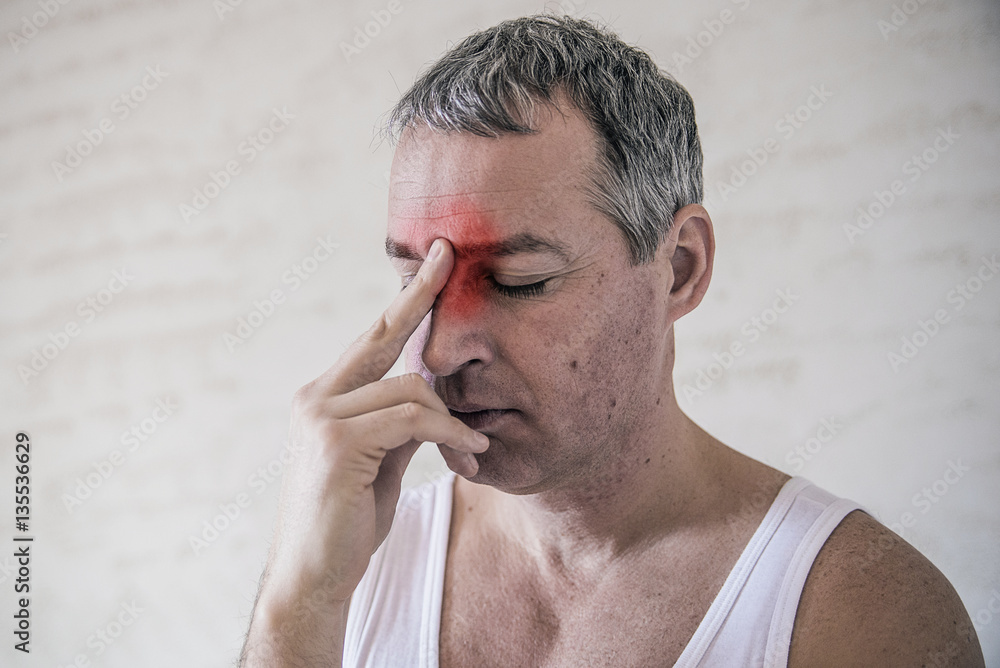 healthcare, pain, stress, age and people concept -man holds his nose ...