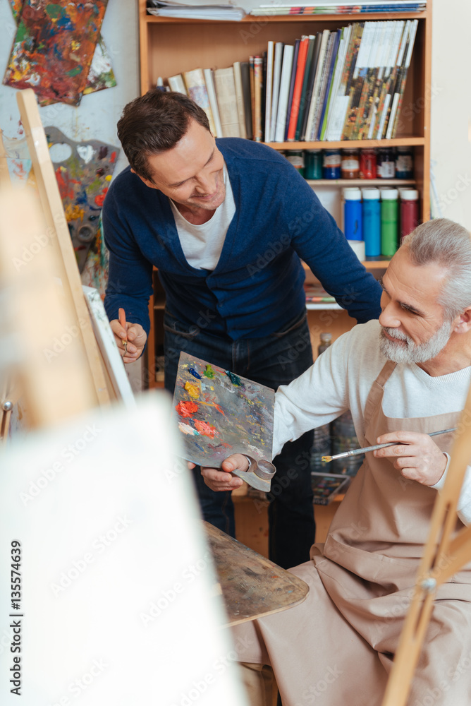 Smiling artist helping elderly man in painting Stock Photo | Adobe Stock