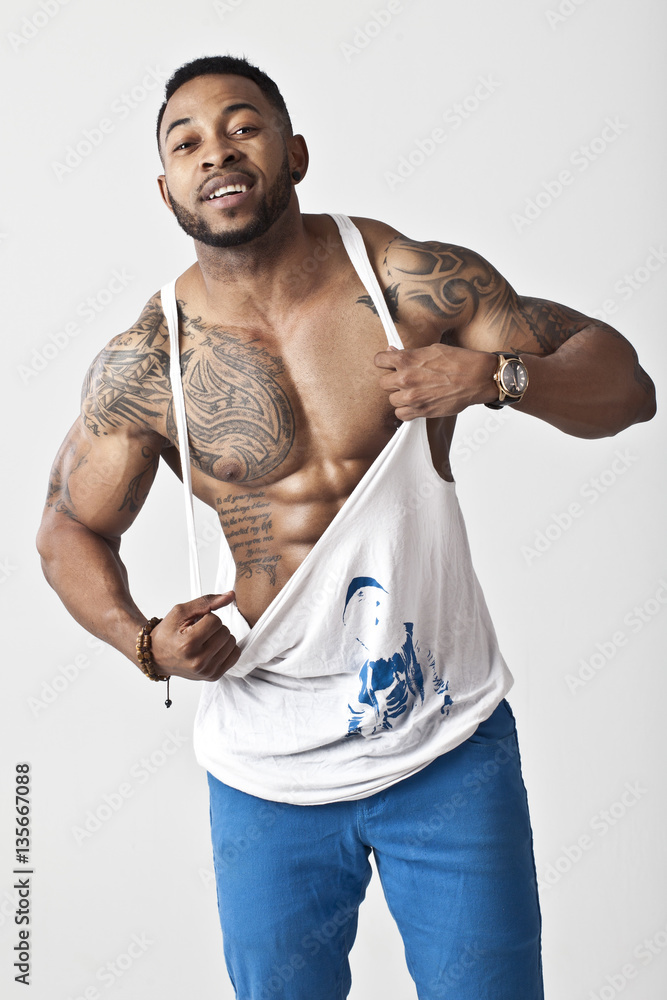 African fitness model pulling shirt down showing off his six pack abs ...