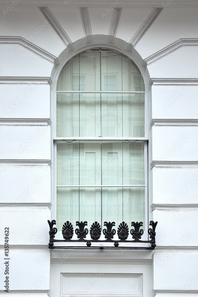 Arched window recessed in white ashlar walling building facade, with an ...