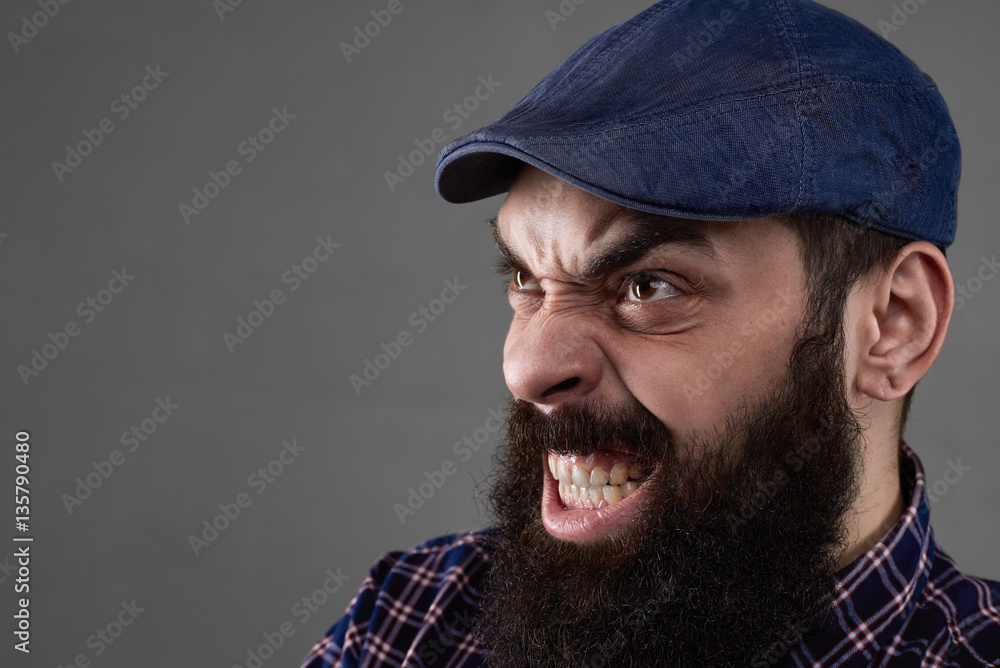 Aggressive emotion with open mouth of bearded man on grey background ...