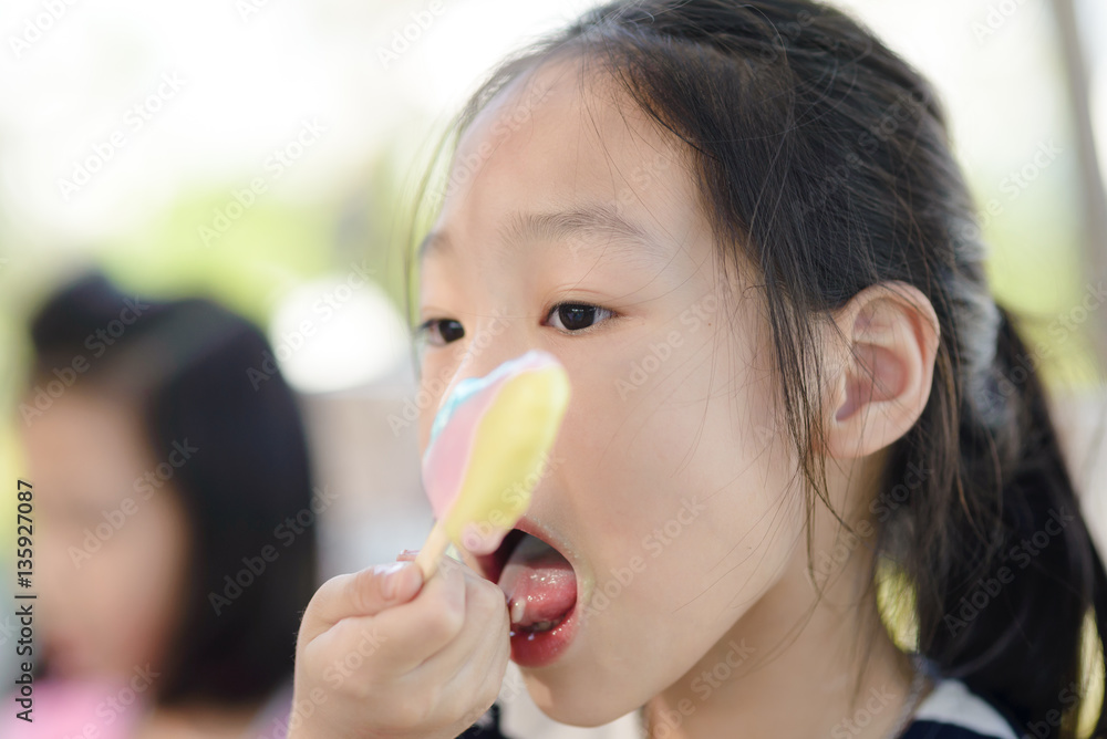 Portrait of Asian girl licking an ice-cream Stock Photo | Adobe Stock