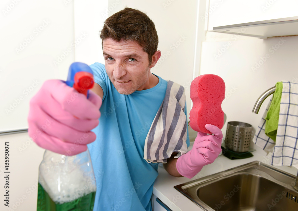 young lazy house cleaner man washing and cleaning the kitchen with ...