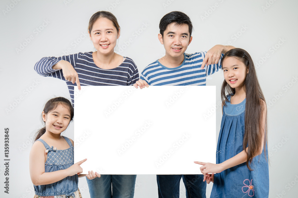 Smiling happy Asian family with big white poster on isolated background ...