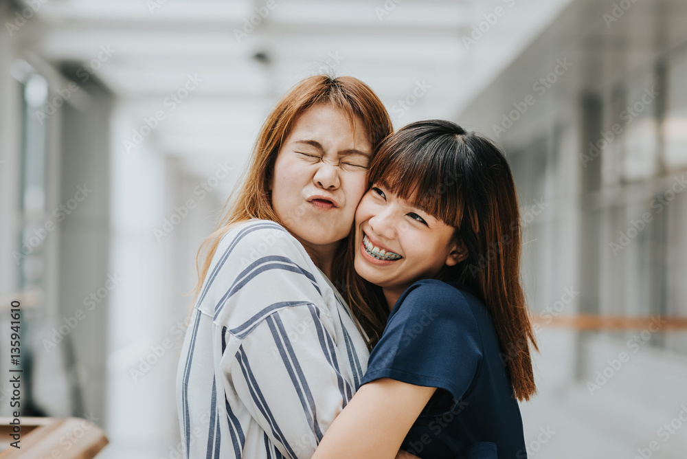 Two beautiful happy Asian girls friends laughing and hug. Friendship ...