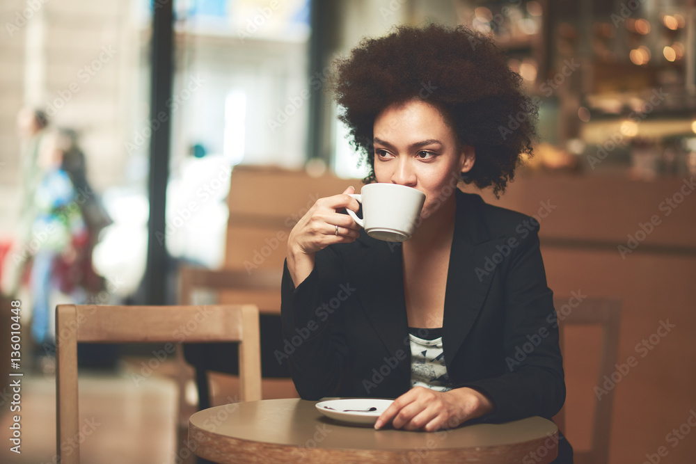 Mixed race, African American woman drinking coffee in cafe Stock Photo ...