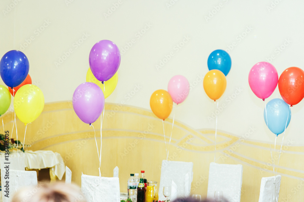 Colorful balloons hang over white dinner table Stock Photo | Adobe Stock