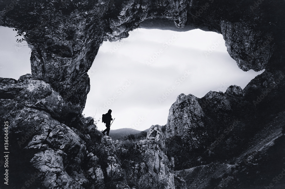 Surreal landscape with man exploring big cave Stock Photo | Adobe Stock
