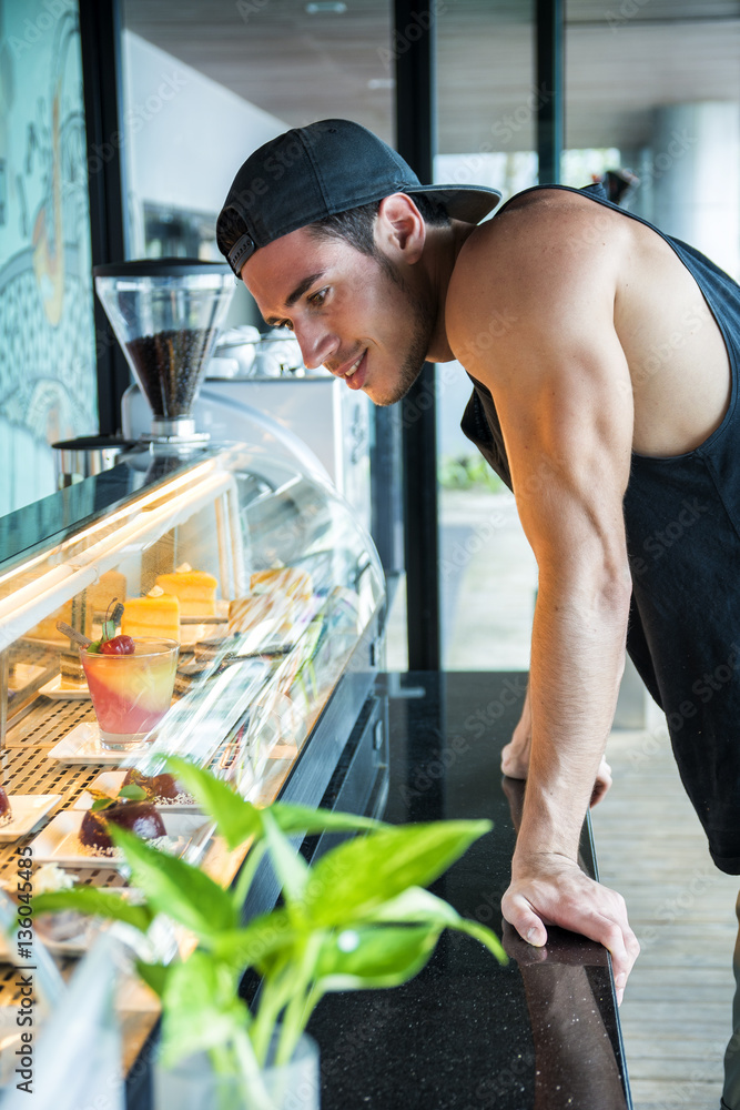 Man standing in cafeteria and choosing the dessert. Vertical indoors ...