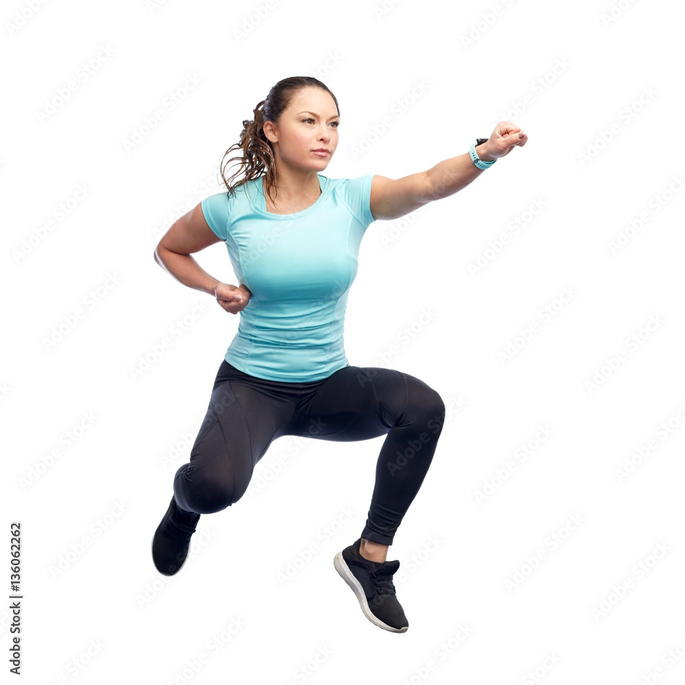 Foto Stock happy sporty young woman jumping in fighting pose | Adobe Stock